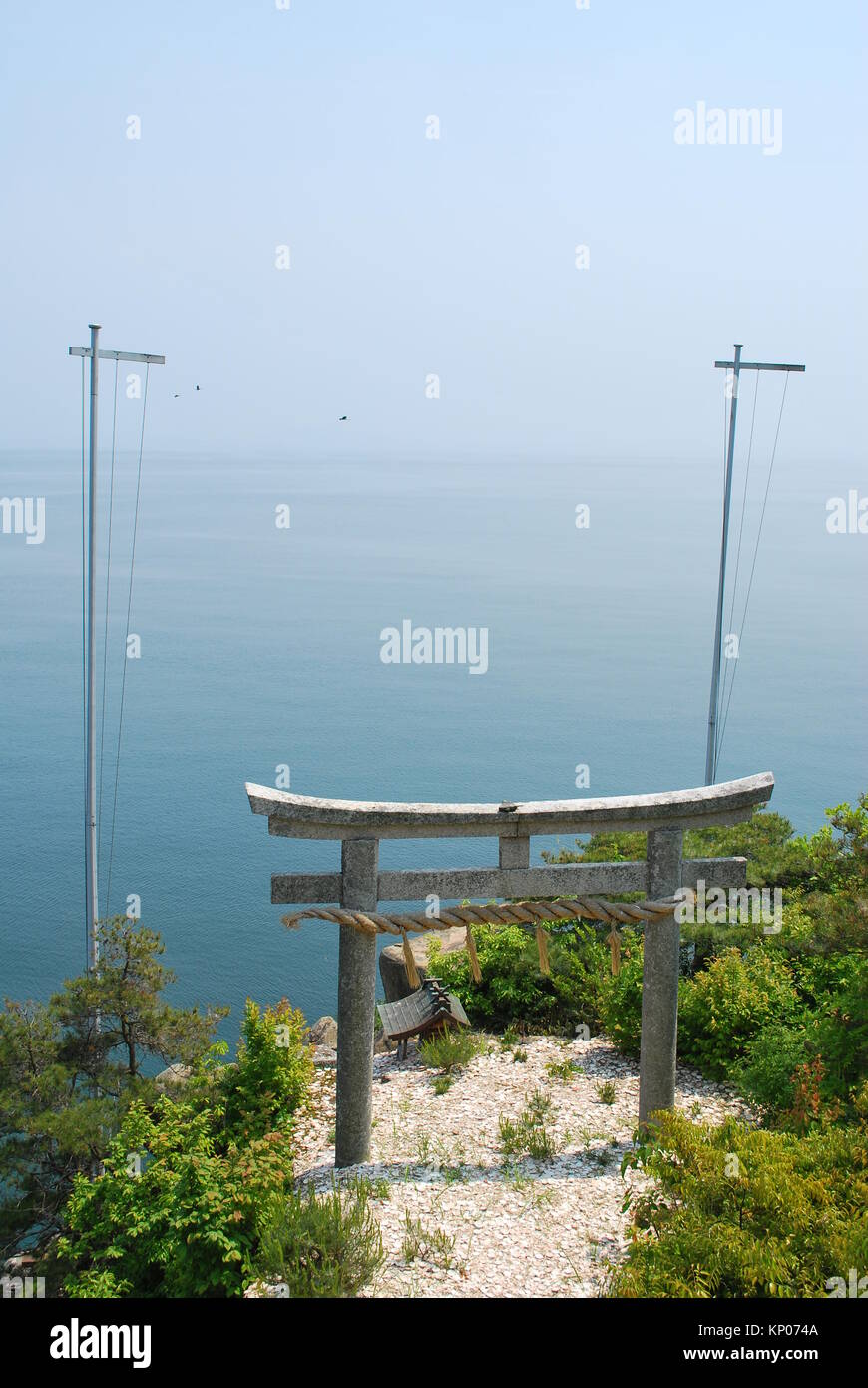 Majestic torii gate of a shrine overlooking the ocean with ships ...
