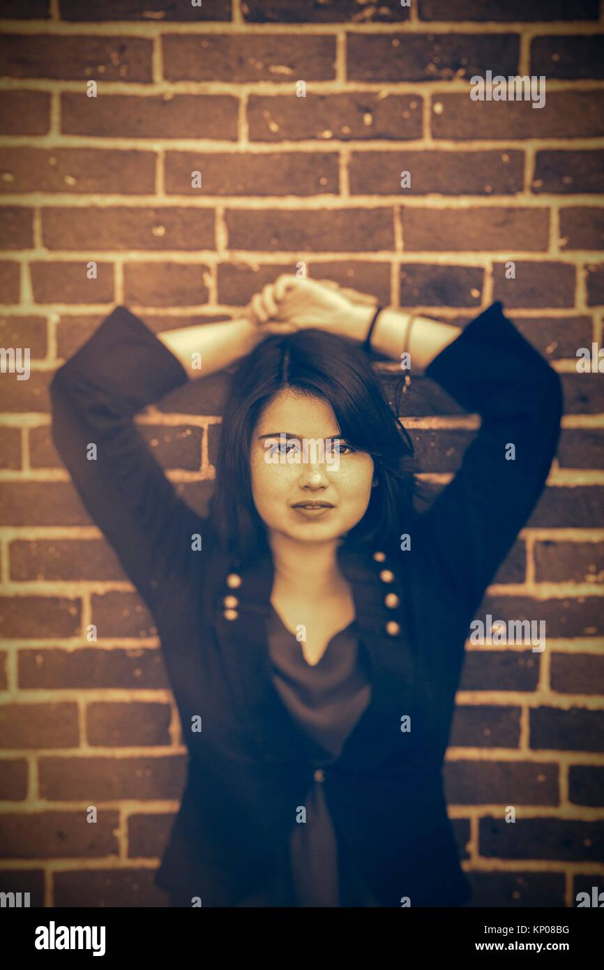 Woman on brick wall hi-res stock photography and images - Alamy