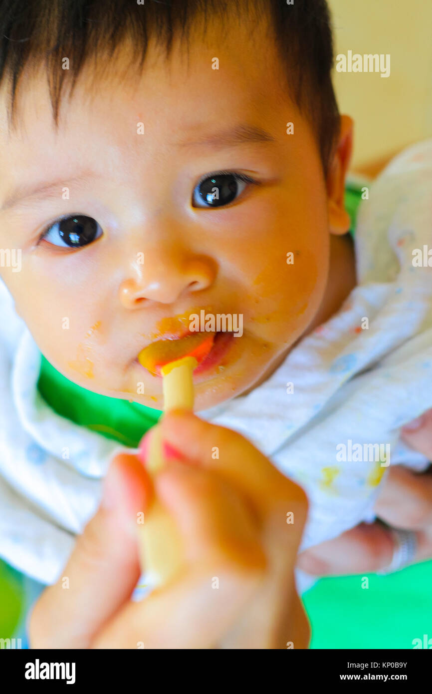 happy eating : little asian boy enjoys eating food Stock Photo - Alamy