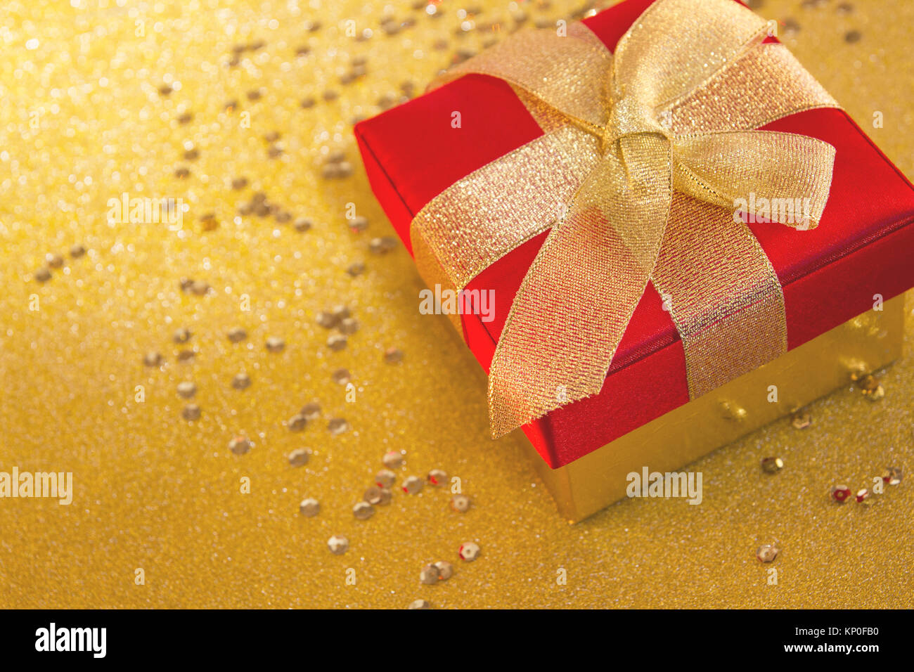 Gift box with ribbon on gold glitter background Stock Photo - Alamy
