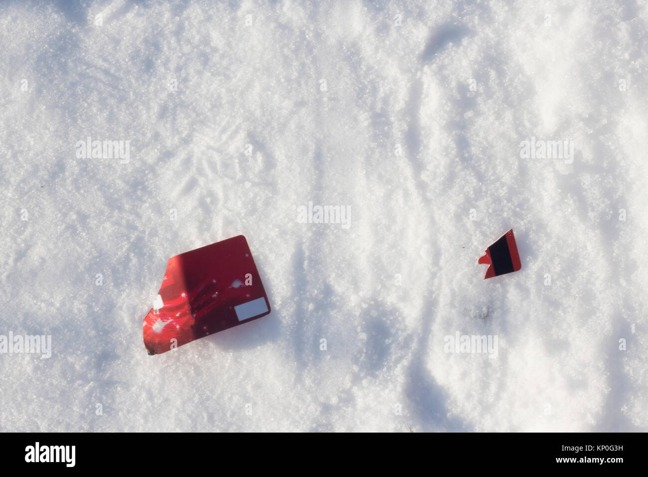 Red broken credit card lies on snow with footprint background Stock ...