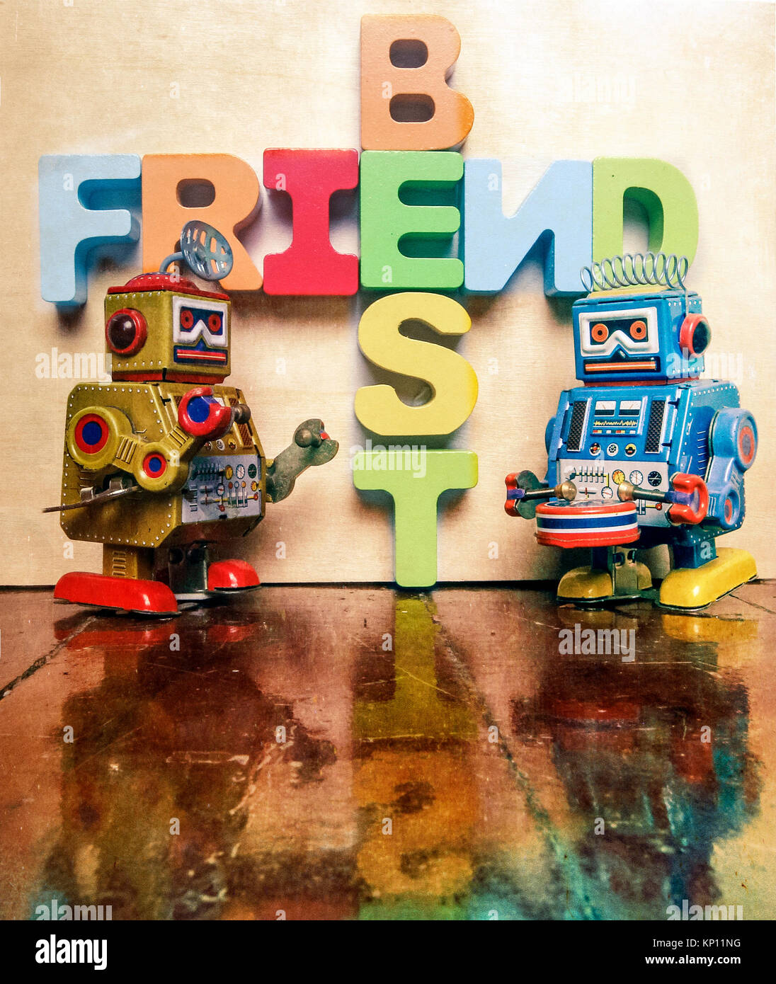 BEST FRIEND word with wooden letters and two retro robot toys on an old ...