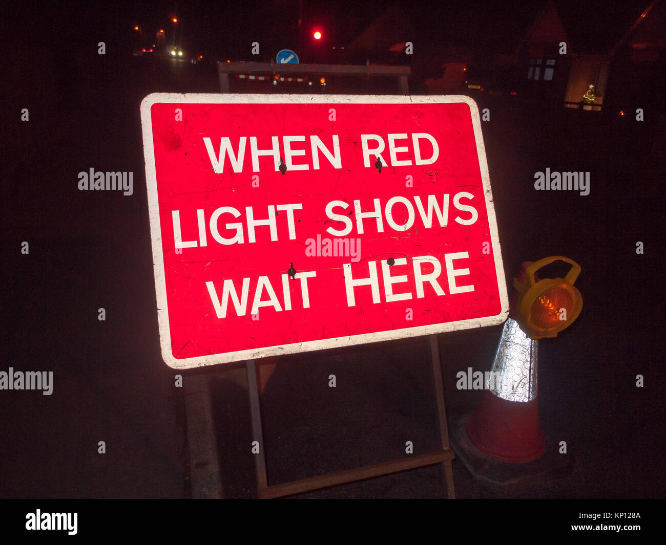 red construction sign at night road when red light shows wait here ...