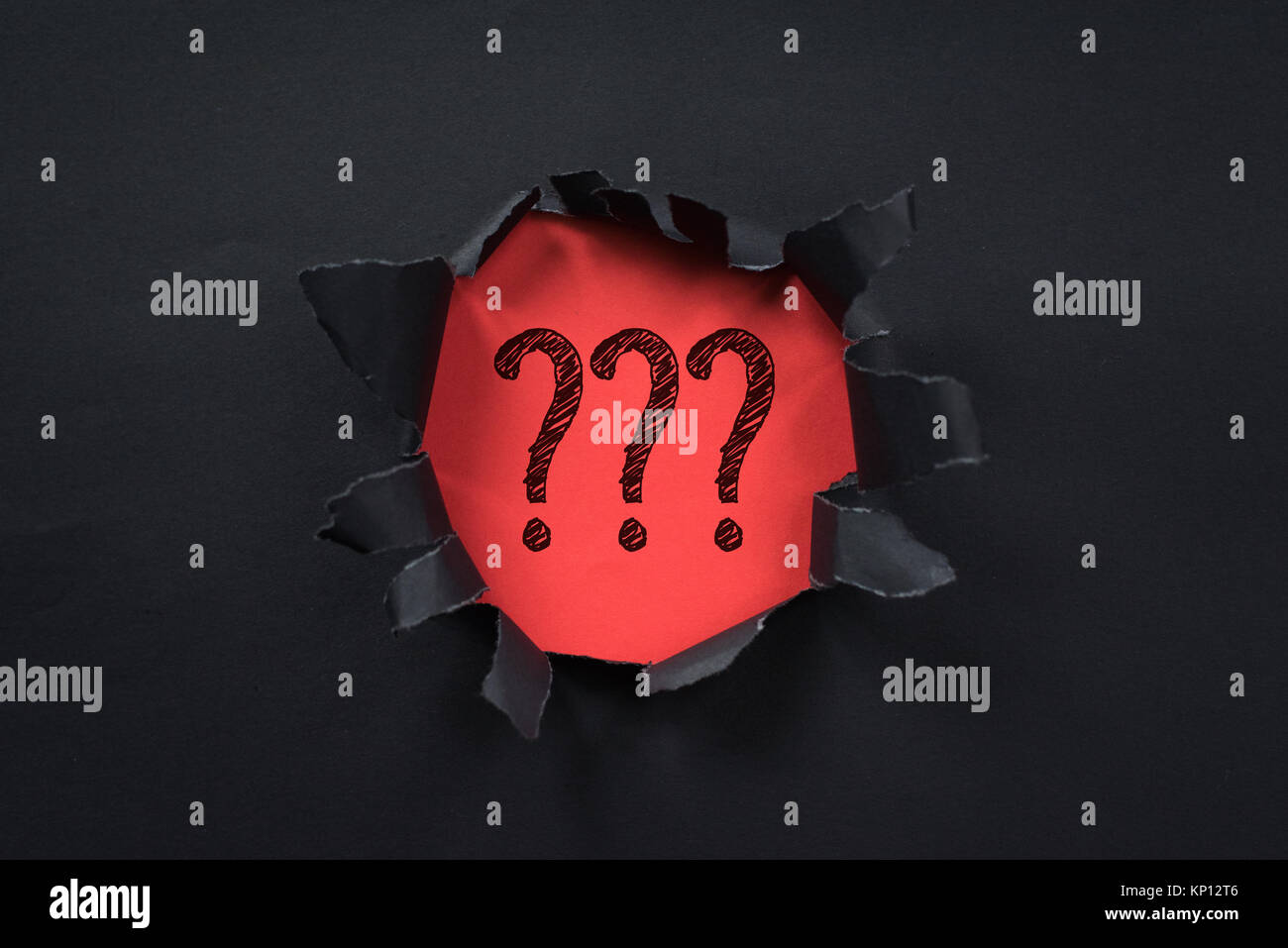 black torn paper revealing question mark on red paper. question mark ...