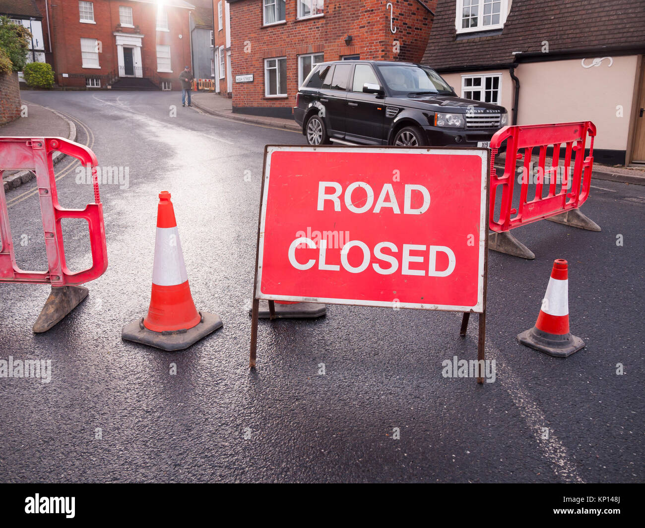 big red road closed sign fences and cones blocked path change direction ...