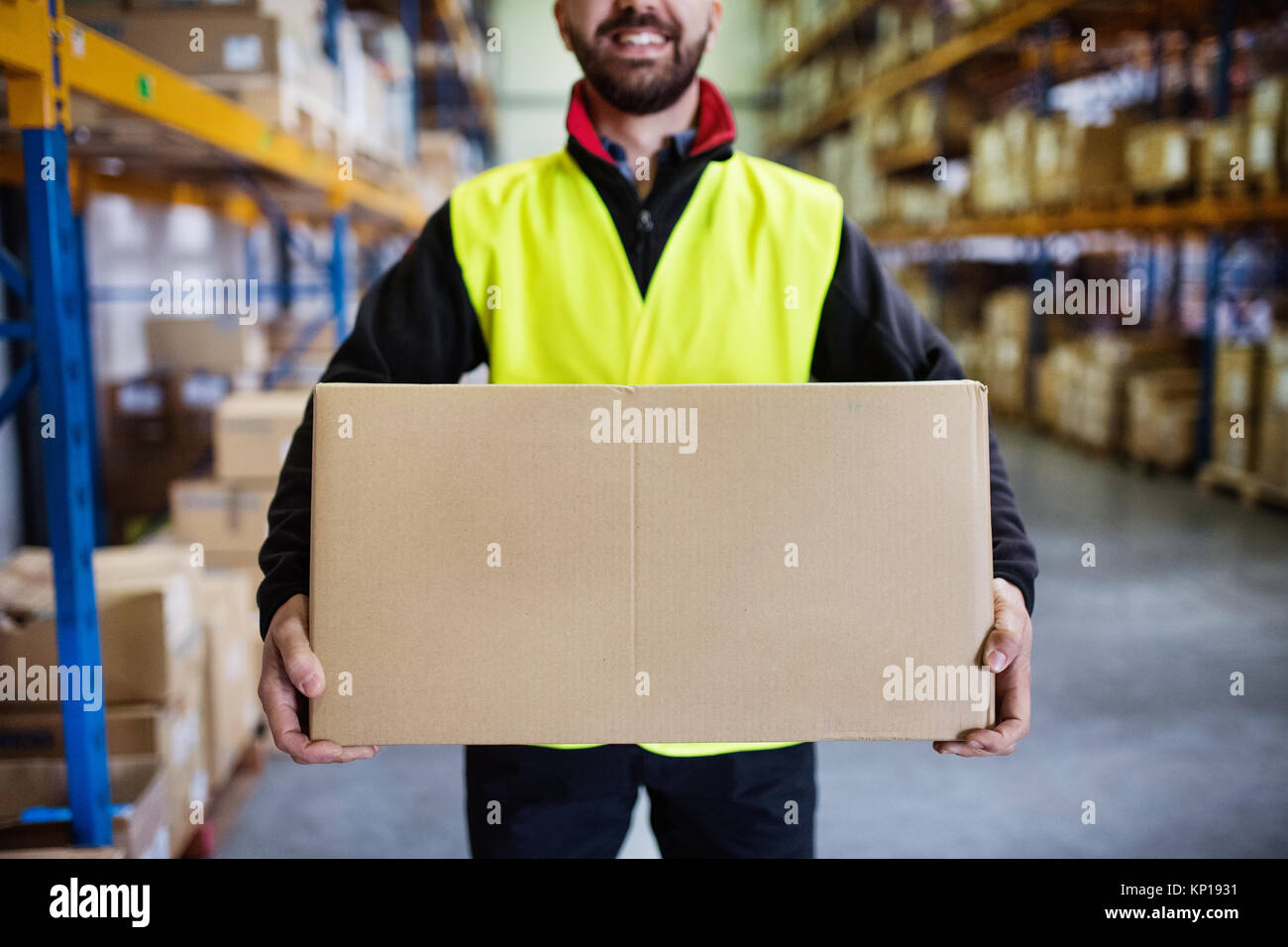 Male warehouse worker with a large box Stock Photo - Alamy