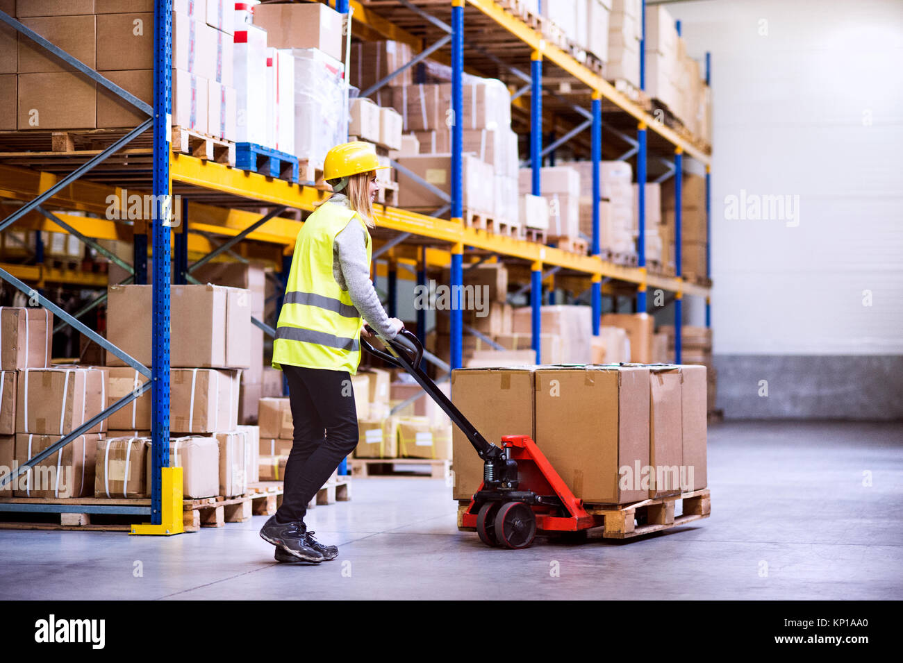 Woman warehouse worker with hand forklift truck Stock Photo - Alamy