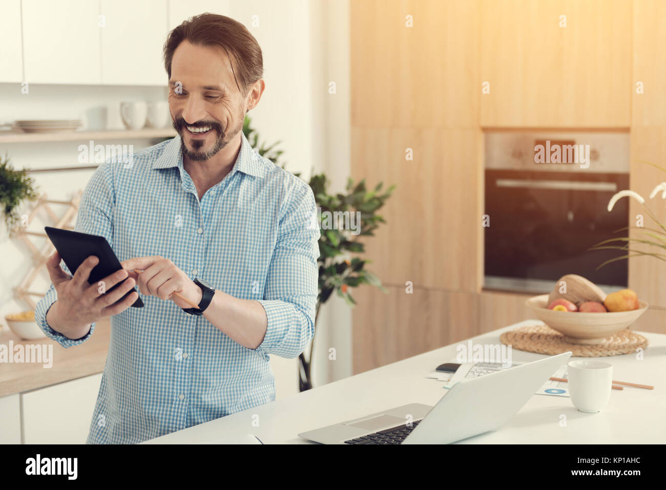 Cheerful handsome man standing in the kitchen Stock Photo - Alamy