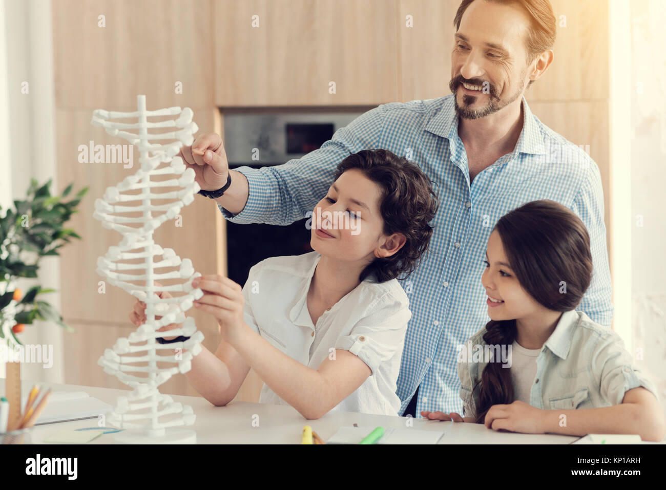 Handsome cheerful man helping his children Stock Photo - Alamy