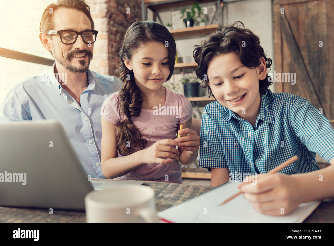 Nice delighted children doing homework together Stock Photo - Alamy