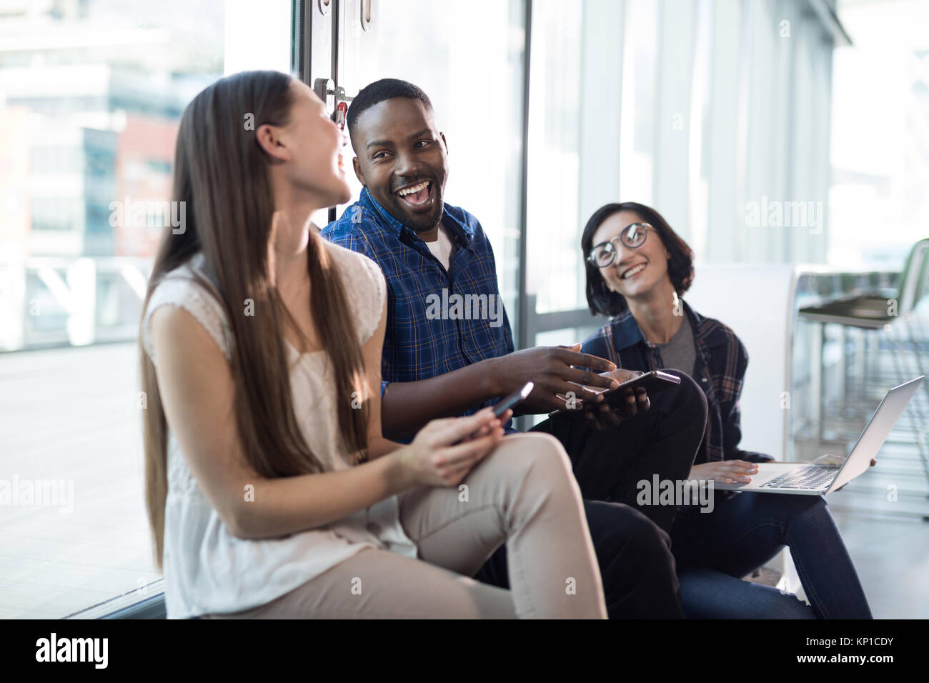 Male and female executives interacting while using electronic gadgets ...