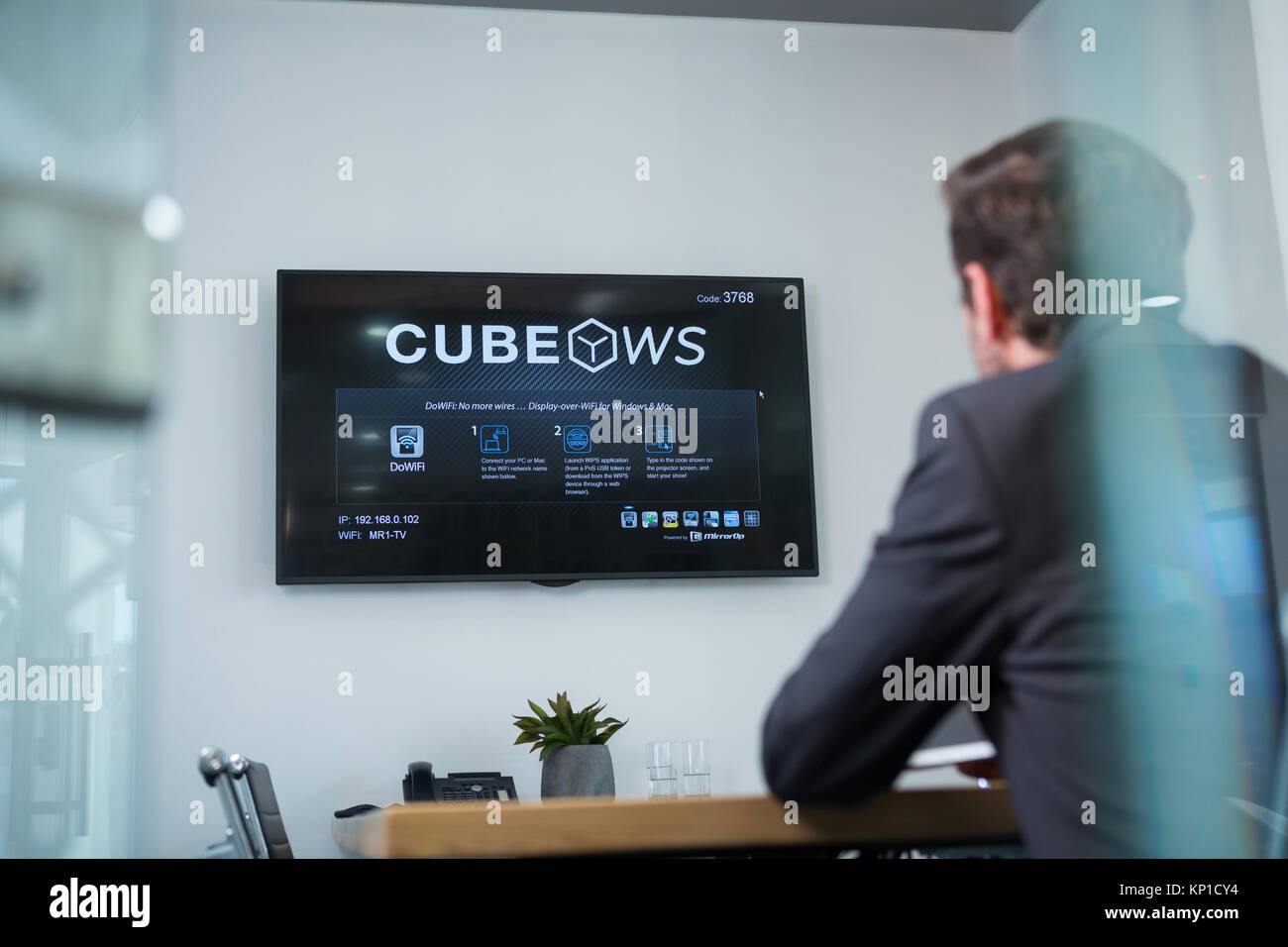 Rear view of businessman watching television in office Stock Photo - Alamy