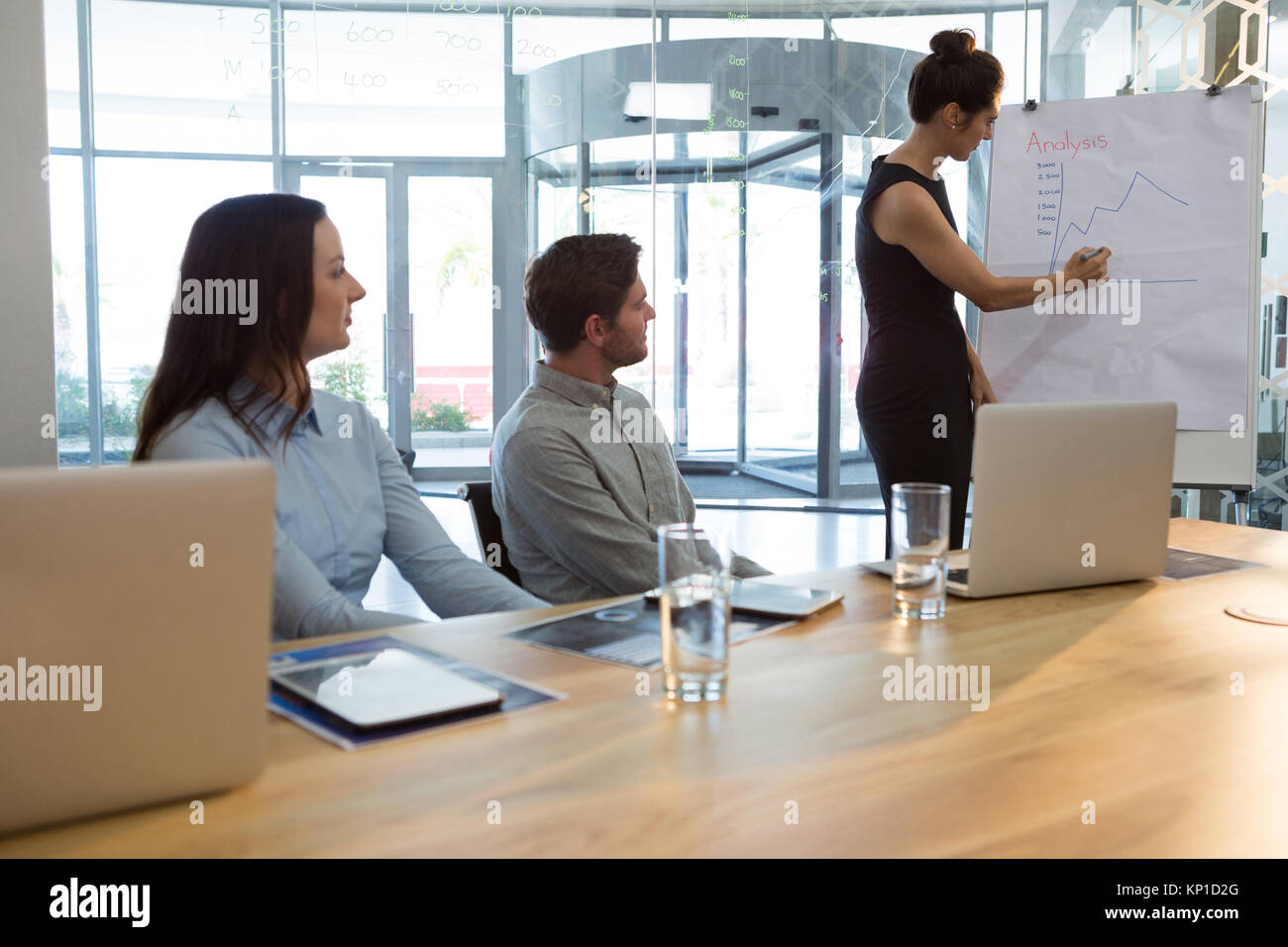 Female executive giving presentation to her colleagues in conference ...