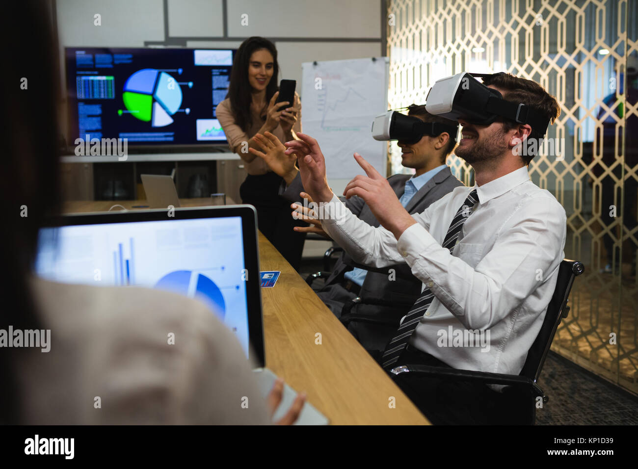 Businessmen using virtual reality headset in conference room at office ...