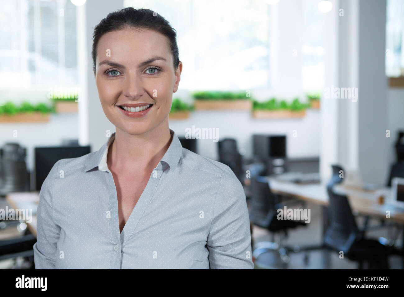 Smiling beautiful female executive looking at camera Stock Photo - Alamy