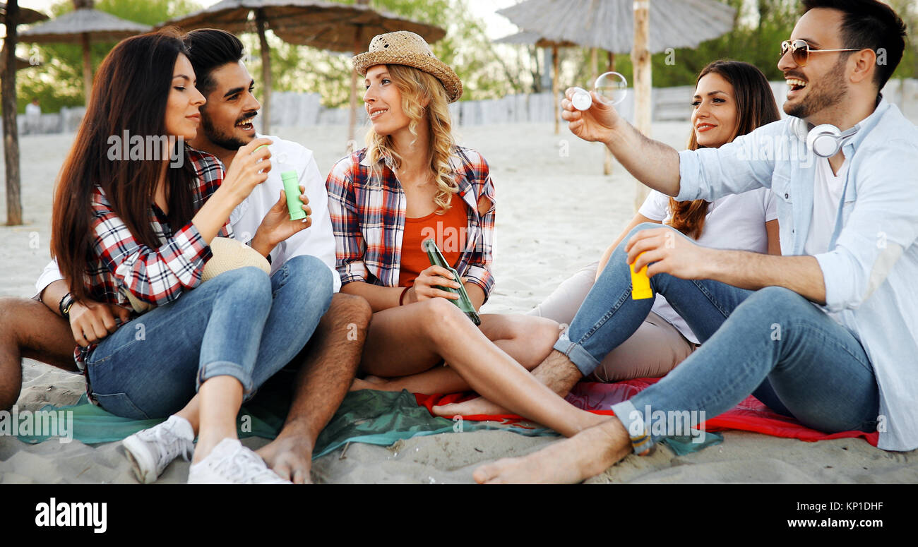 Group of happy friends partying on beach Stock Photo - Alamy