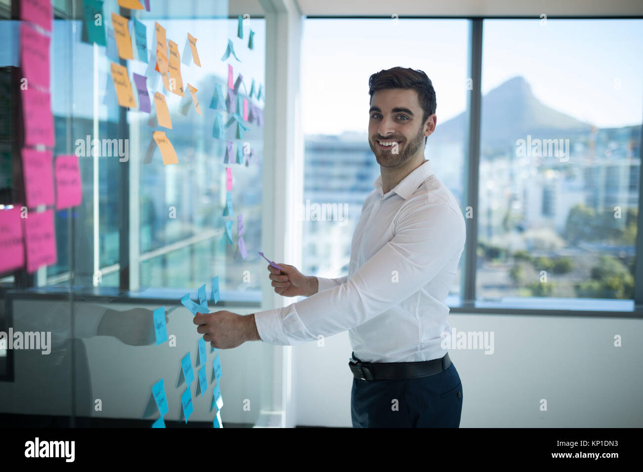 Male executive reading sticky note in office Stock Photo - Alamy