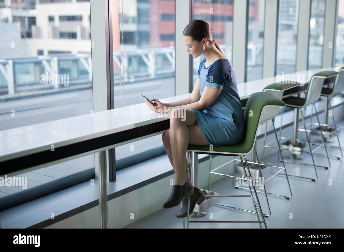 Female executive using mobile phone in office Stock Photo - Alamy