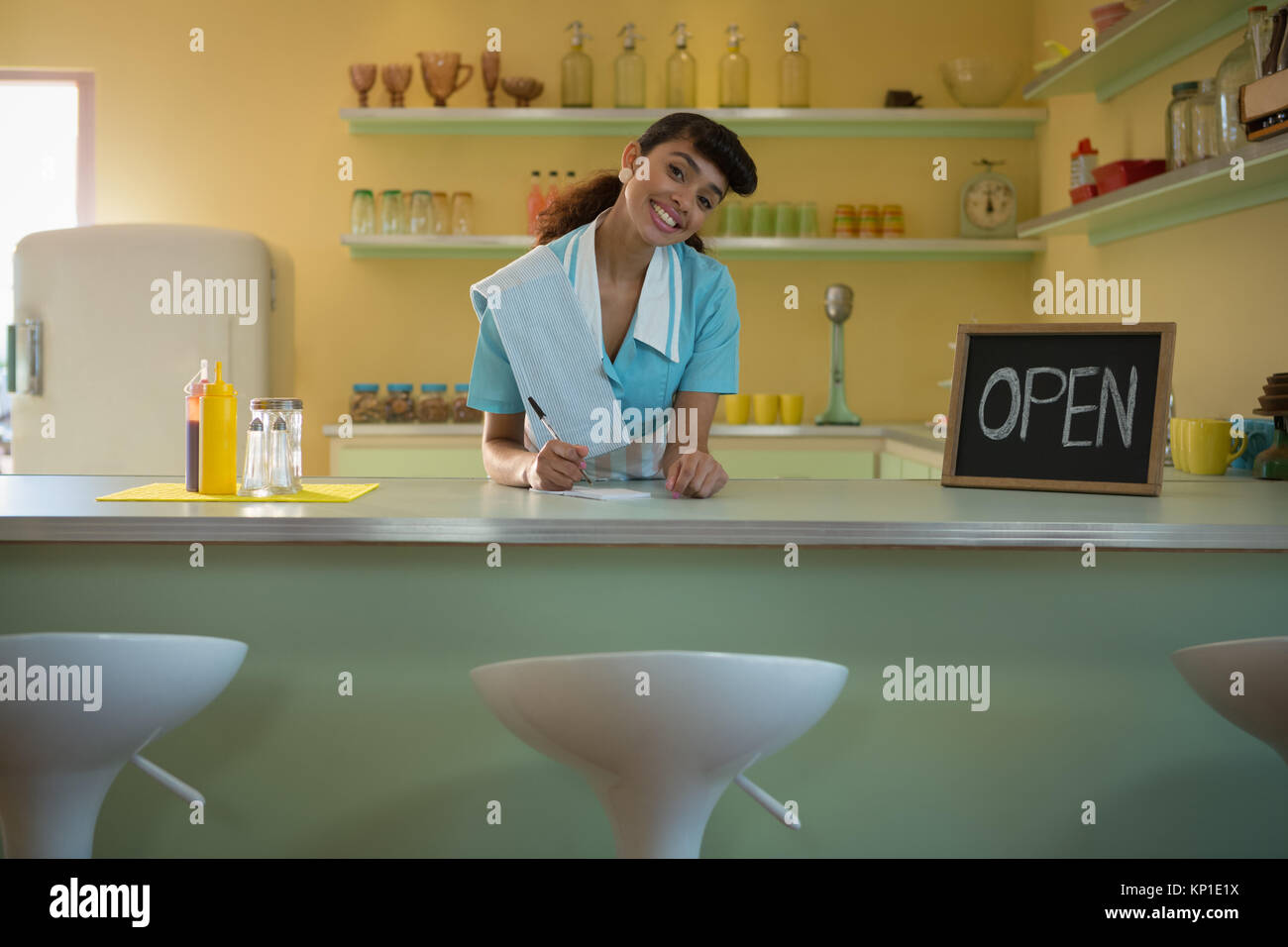 Portrait of waitress standing at counter in restaurant Stock Photo - Alamy