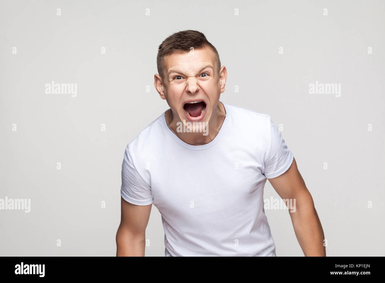 Young boy roar at camera. Isolated on gray background, studio shot ...