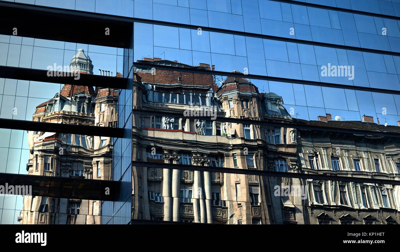 Architecture contrast old house reflection in glass windows of a new ...