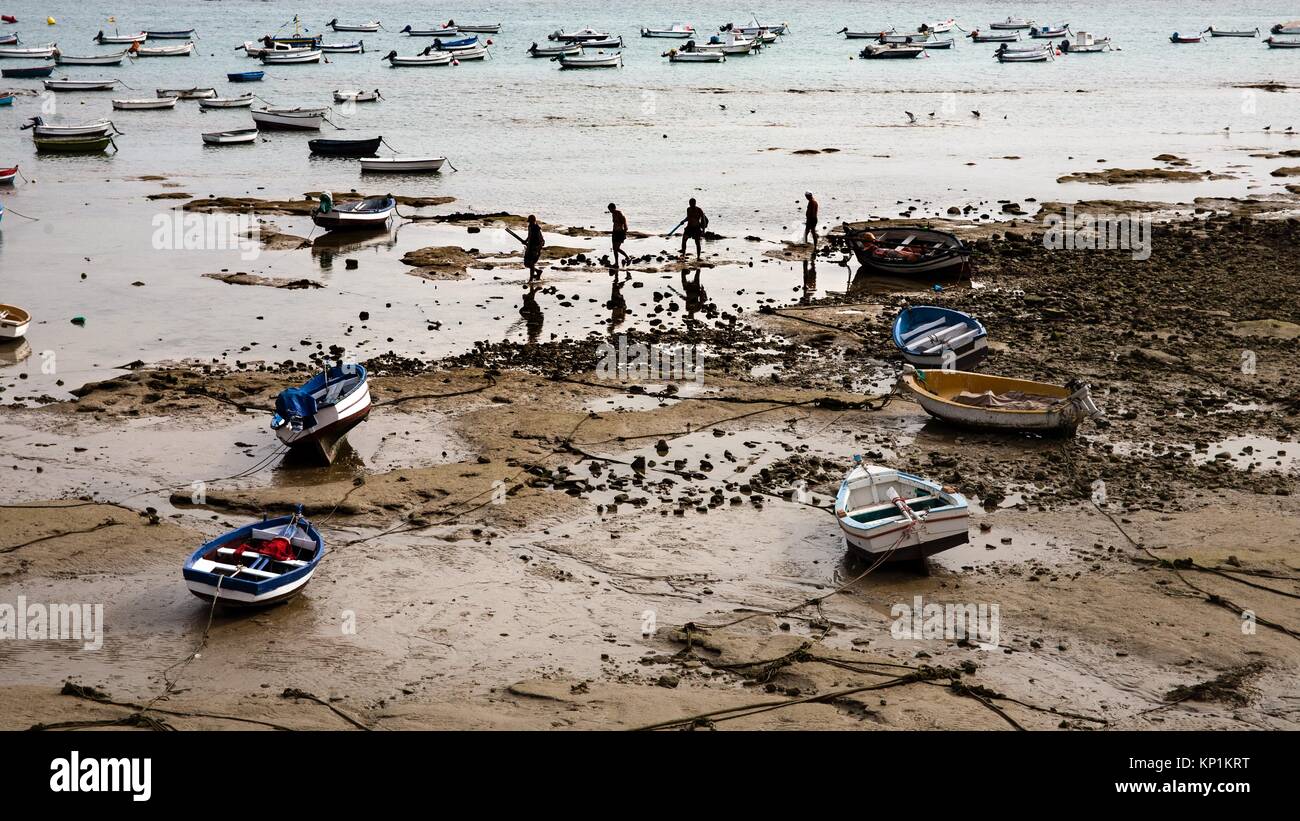 Atlantic Ocean scene during low tide with boats and silhouette of ...