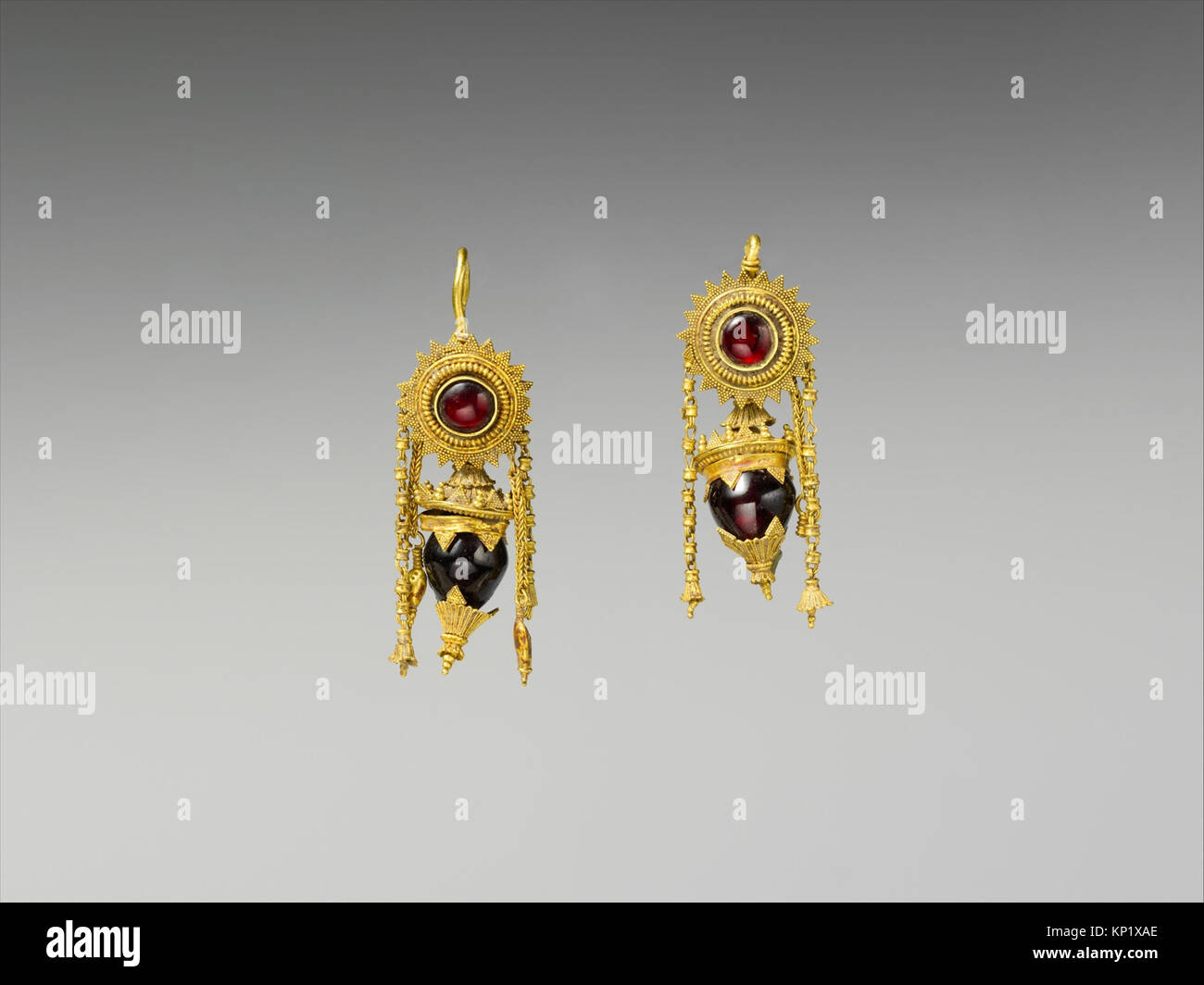 This earring, with a central disc and hanging chains, illustrates ...