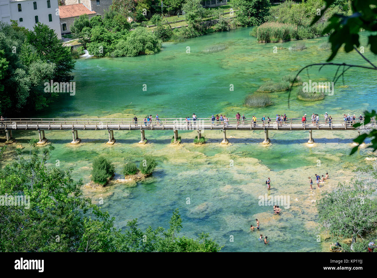 Tourists walk over bridge at waterfall Skradinski Buk in Krka National ...