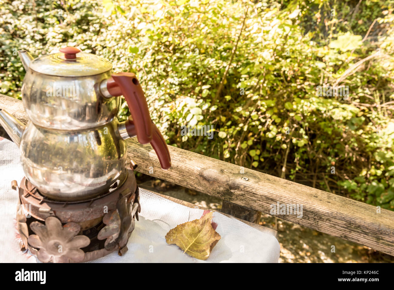 Traditional Turkish tea making pot on a fire at wooden table is waiting ...