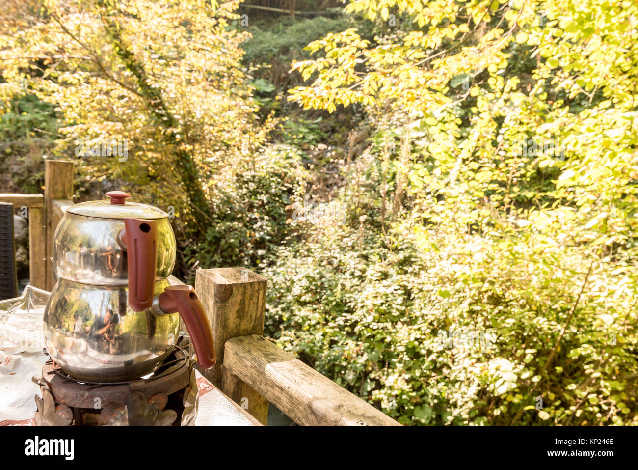 Traditional Turkish tea making pot on a fire at wooden table is waiting ...