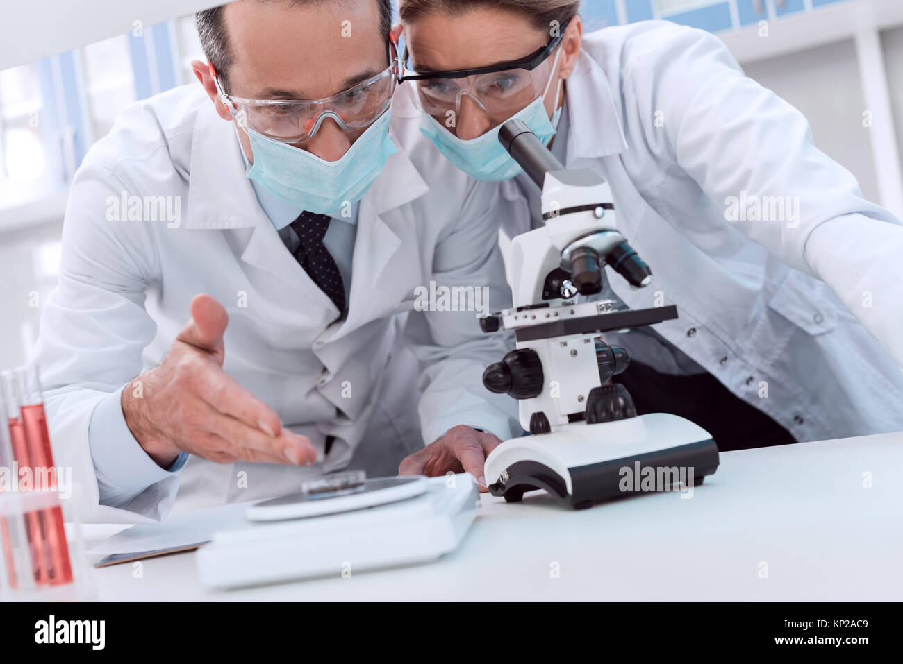 Doctors doing microscope analysis Stock Photo - Alamy