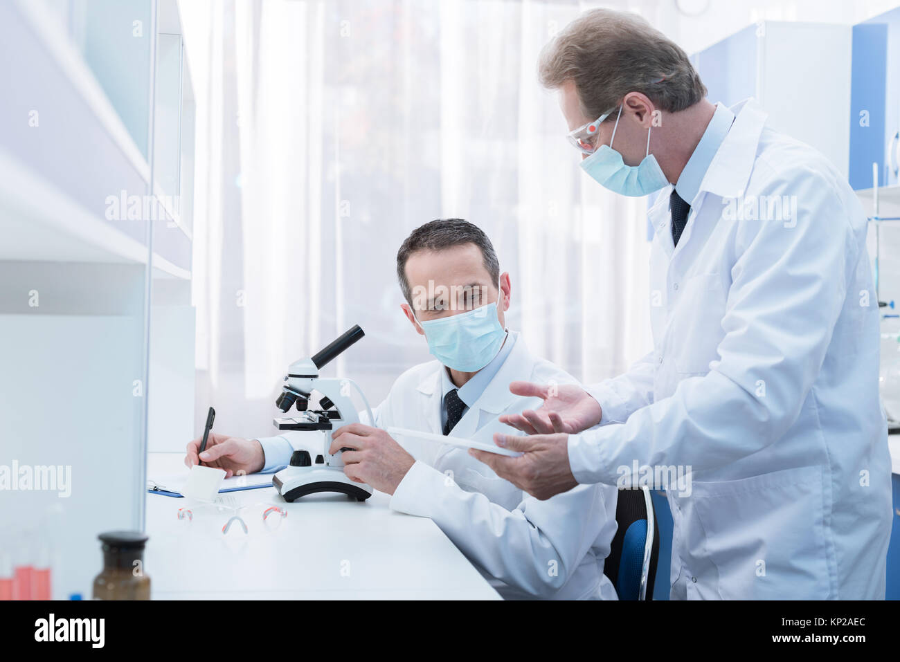 Scientists talking while working in lab Stock Photo - Alamy