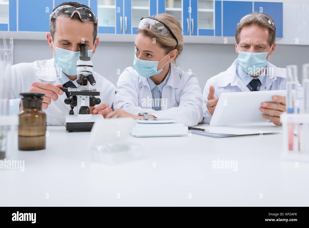 Doctors working with microscope Stock Photo - Alamy