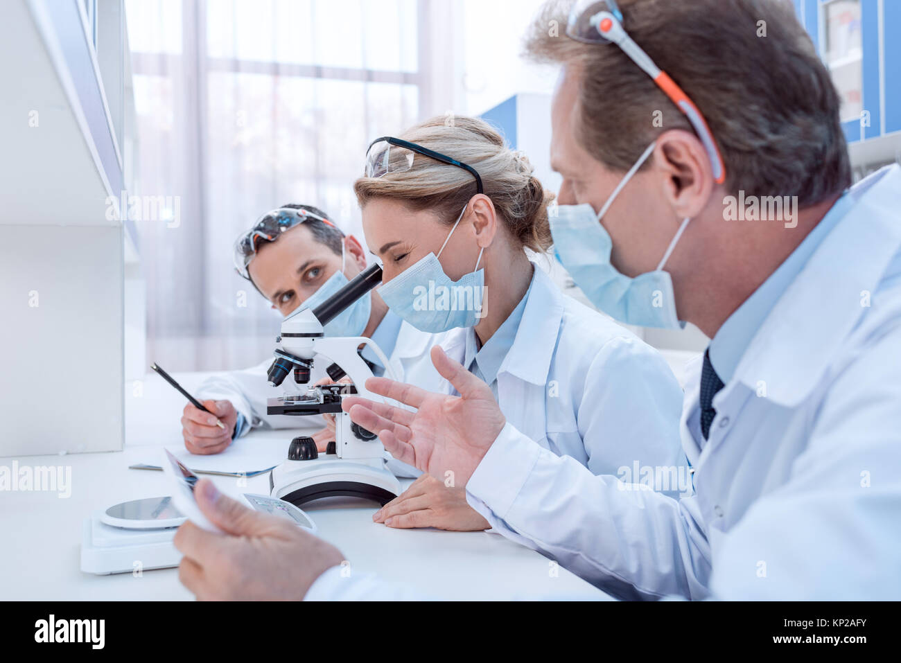 Scientists doing microscope analysis Stock Photo - Alamy