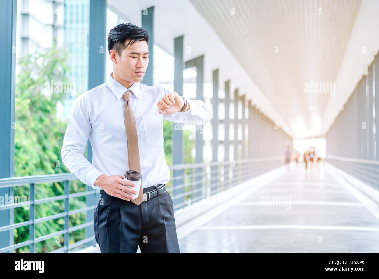 Businessman looking at watch he looks on the time Stock Photo - Alamy
