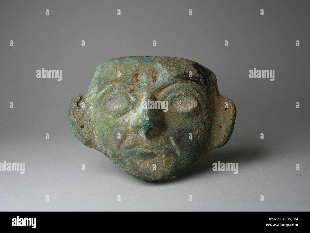 This face mask ornament is an ancient decorative artifact, representing ...