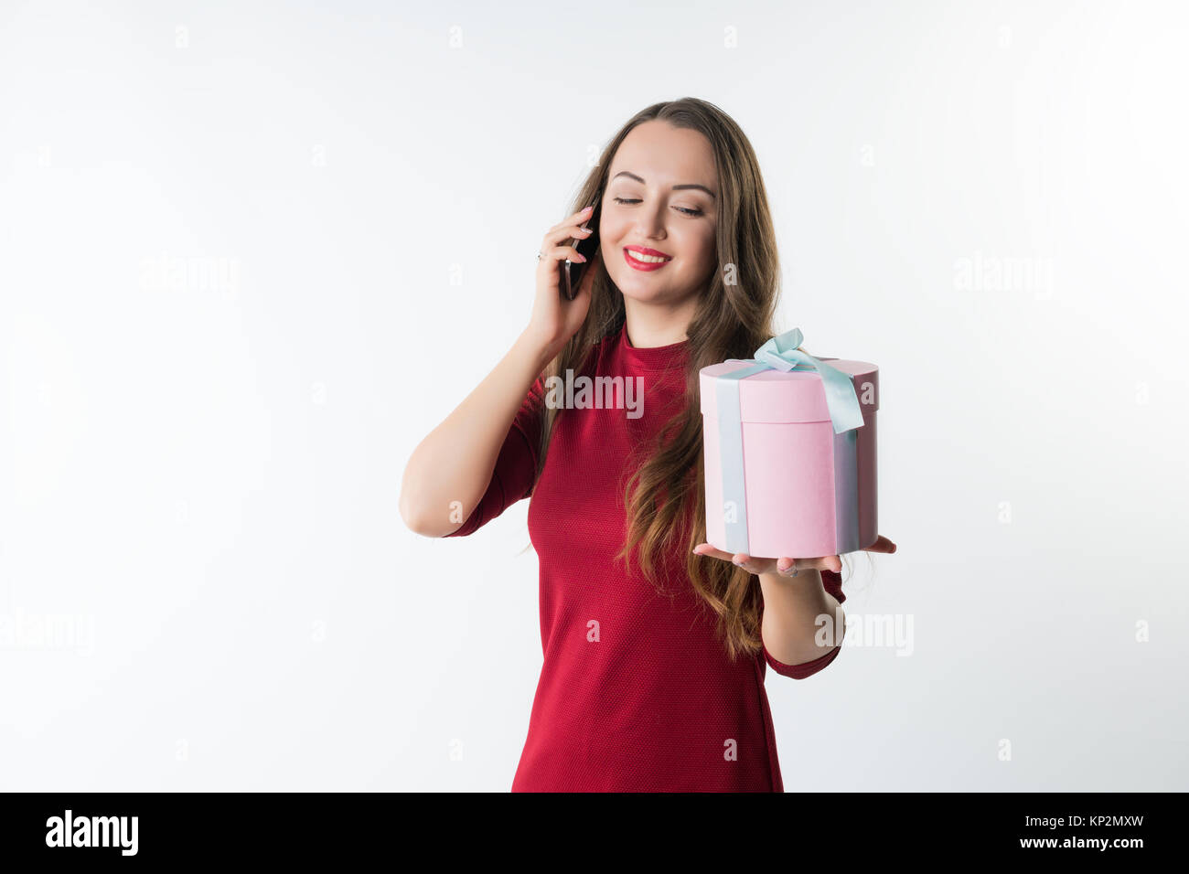Smiling girl with gifts calling on her phone Stock Photo - Alamy