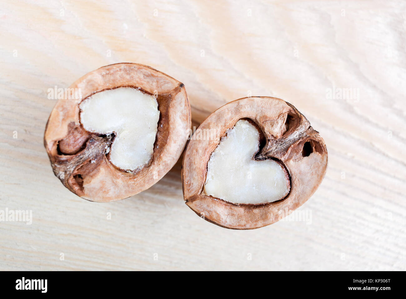 Two halves of walnut in shape of heart are lying side by side on a ...