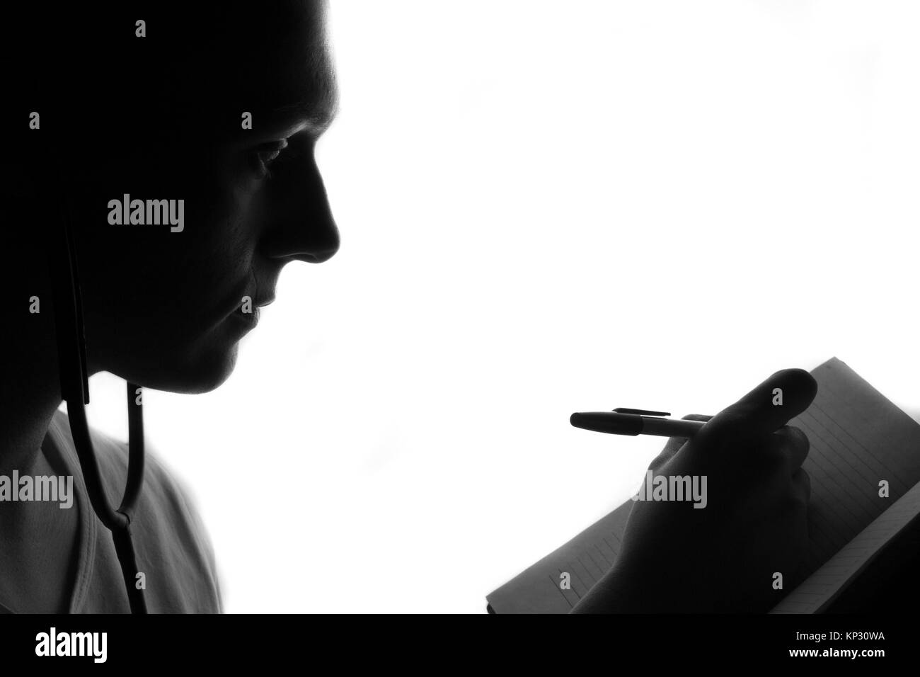 silhouette of a young man writing in a book with a stethoscope ...