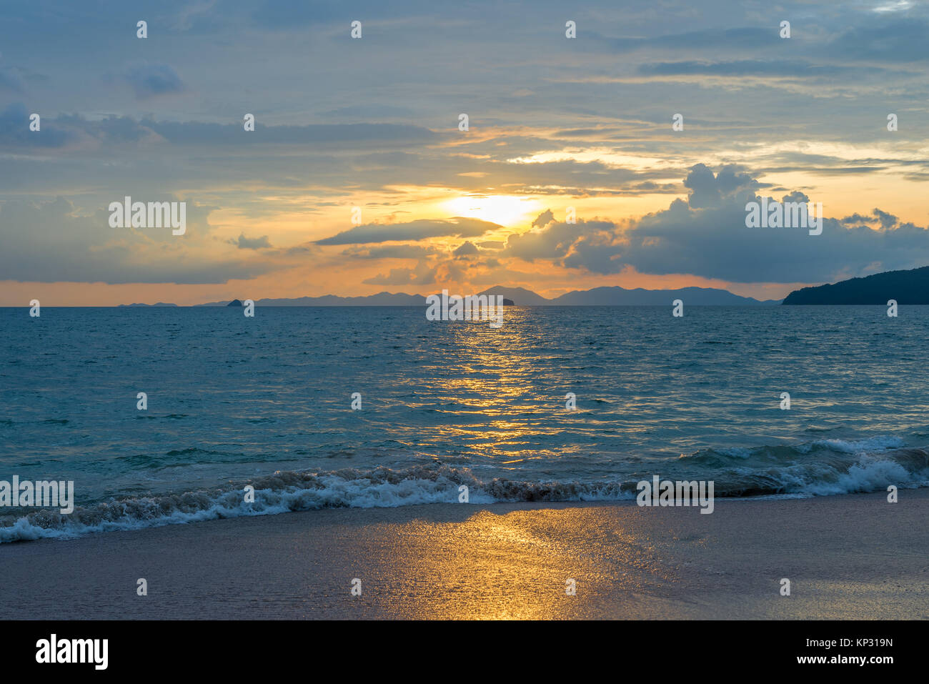 clean beautiful sea in the rays of the setting sun with mountains on ...