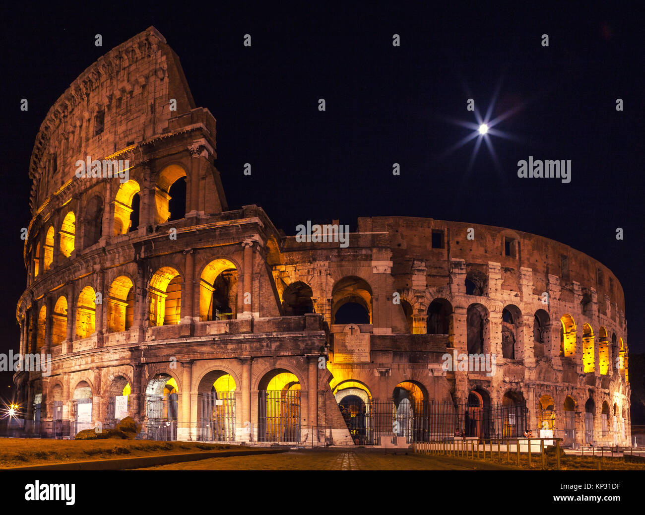 View of ancient Coliseum with illuminated stone windows under dark sky ...