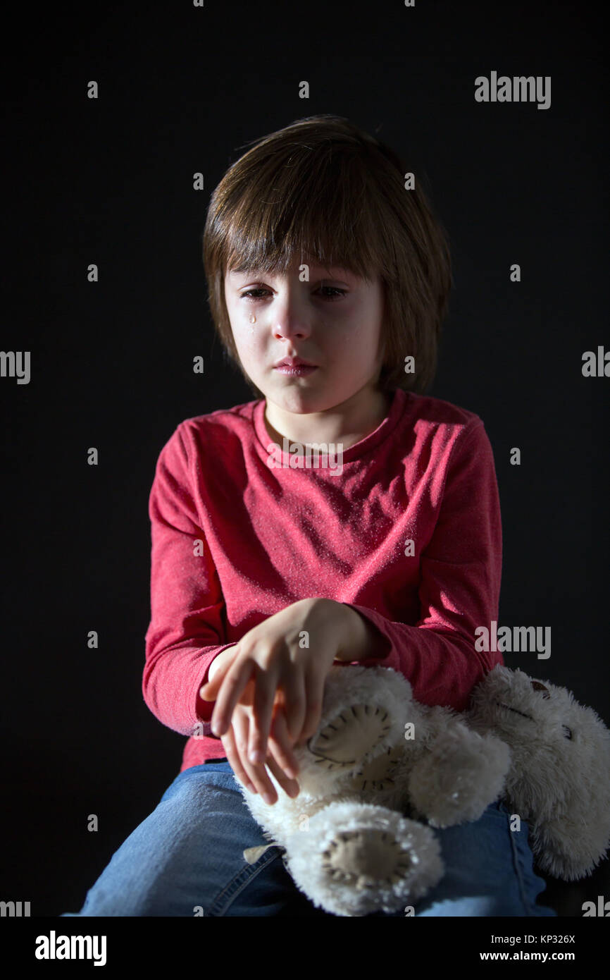 Sad little child, crying, hugging stuffed toy, tears in his eyes Stock ...
