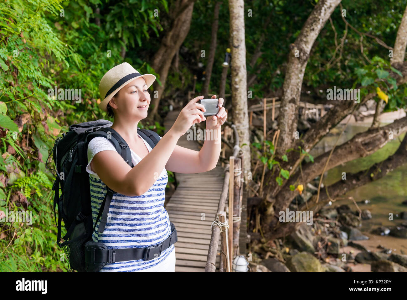 happy tourist on vacation photographs beautiful landscapes on the phone ...