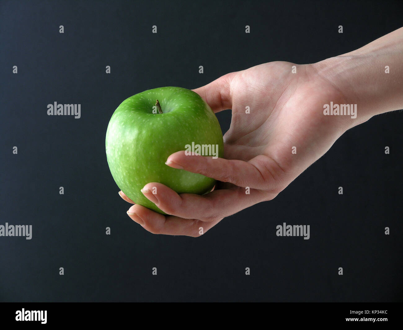 Apple in hand on black background Stock Photo - Alamy