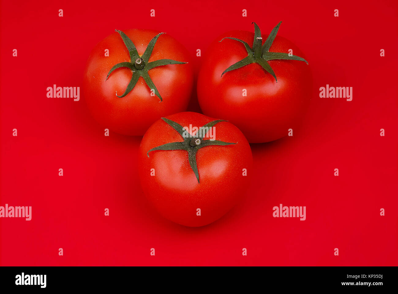 Group of red tomatos on red background Stock Photo - Alamy