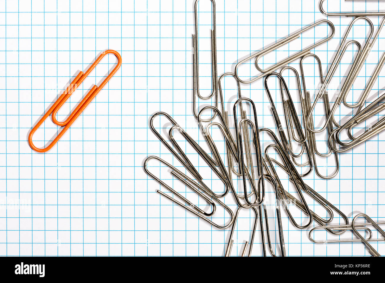 orange paper clip with silver paper clips on a grilled background Stock ...