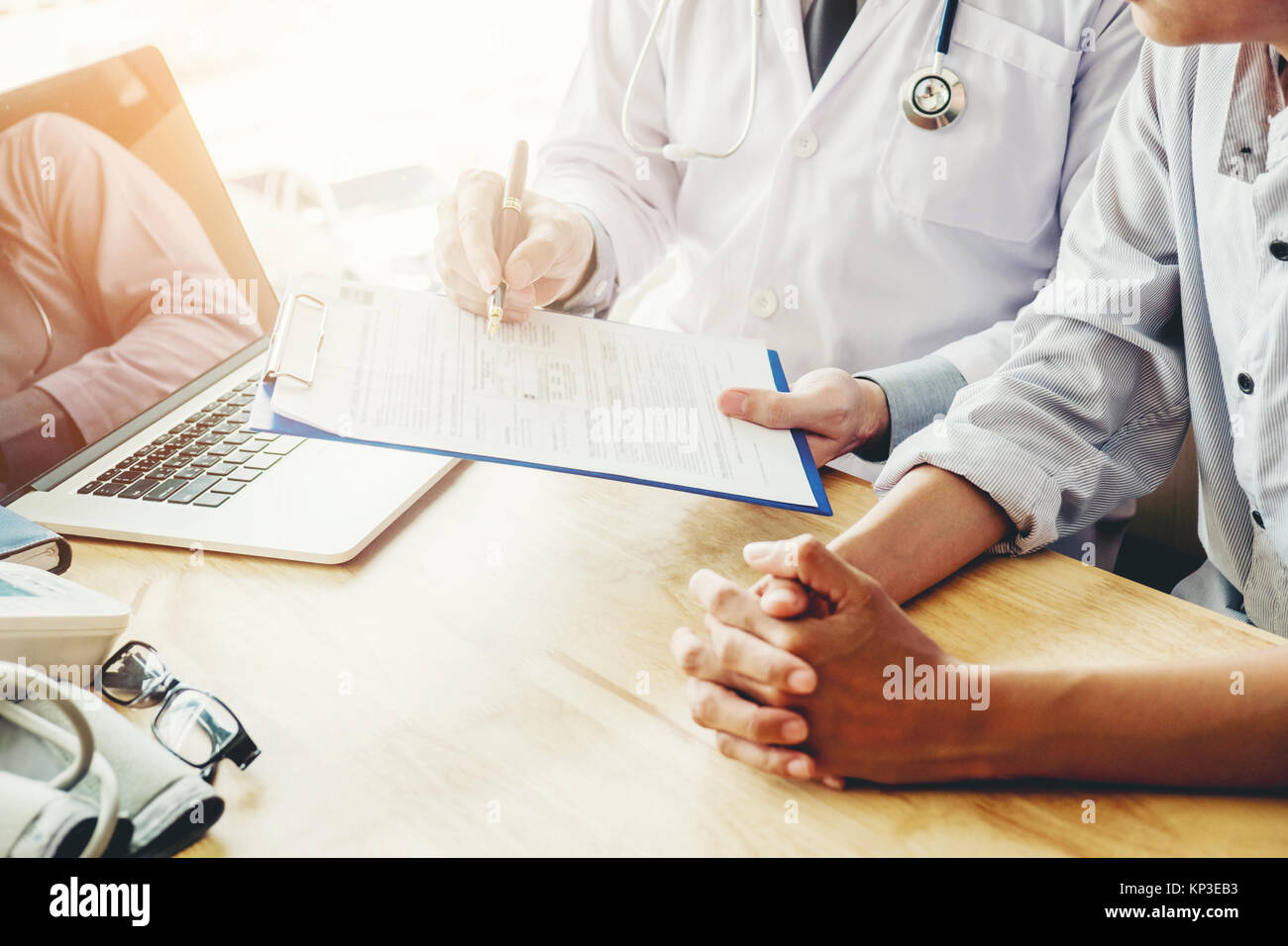Doctors and patients sit and talk. At the table near the window in the ...
