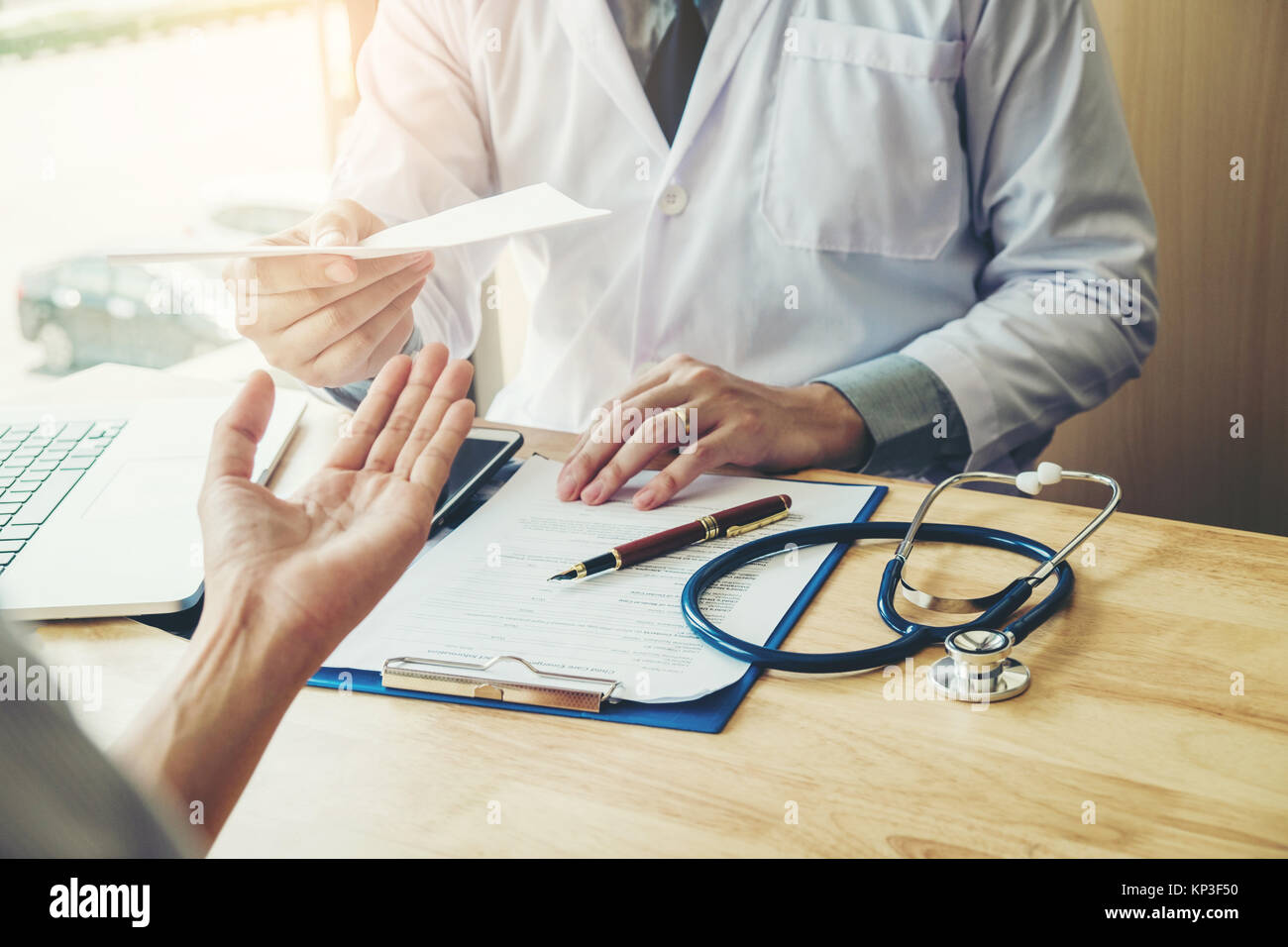 Doctor or physician writing diagnosis and giving a medical prescription ...