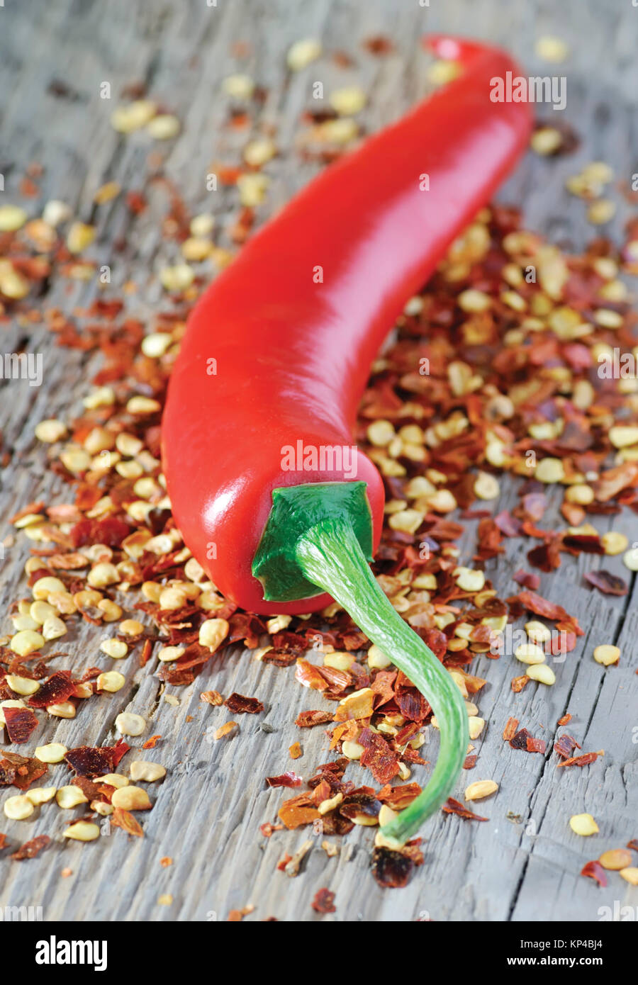 red chilli pepper resting on a bed of crushed chilli flakes Stock Photo ...