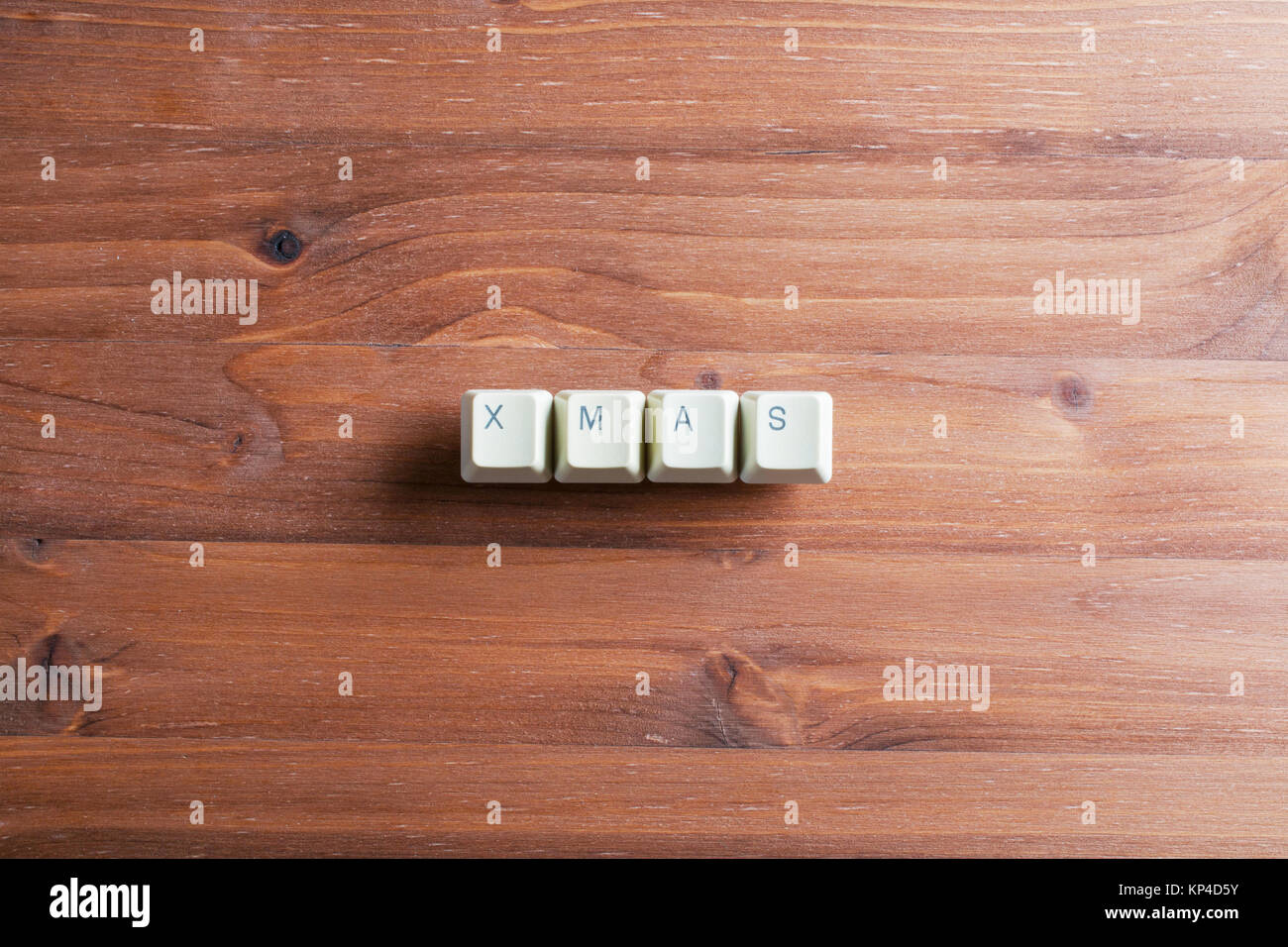 Xmas word. Flat lay view from above on the table with computer keyboard keys buttons on a wooden ...